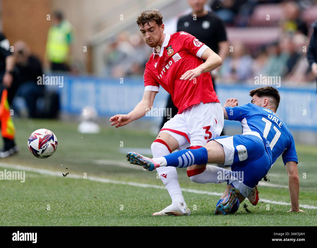 Wrexham's Lewis Brunt and Wigan's Owen Dale battle for the ball during ...