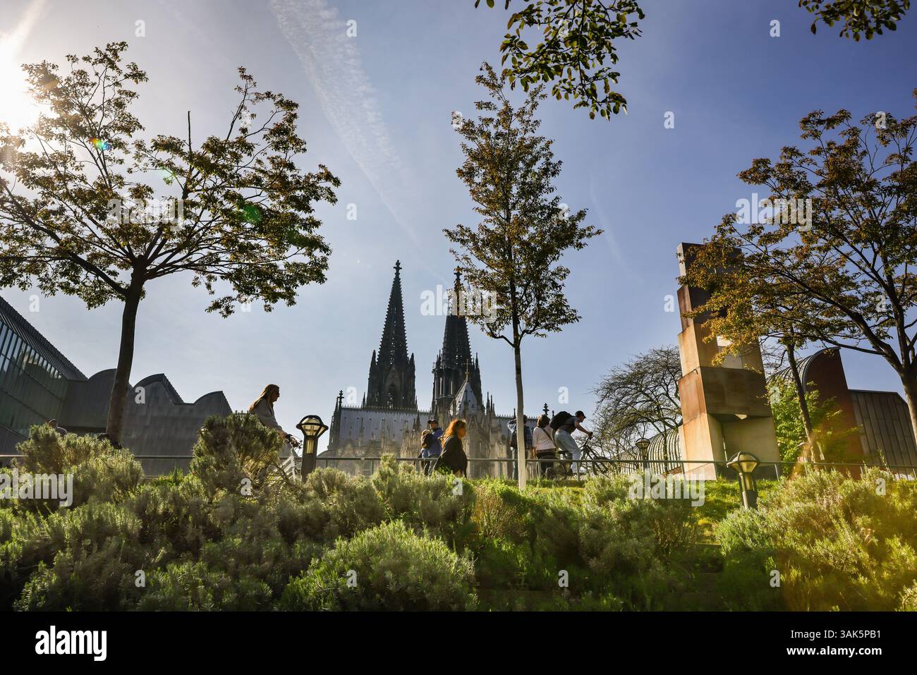 Cologne, Germany, 11th April 2025. People stroll through the greenery ...