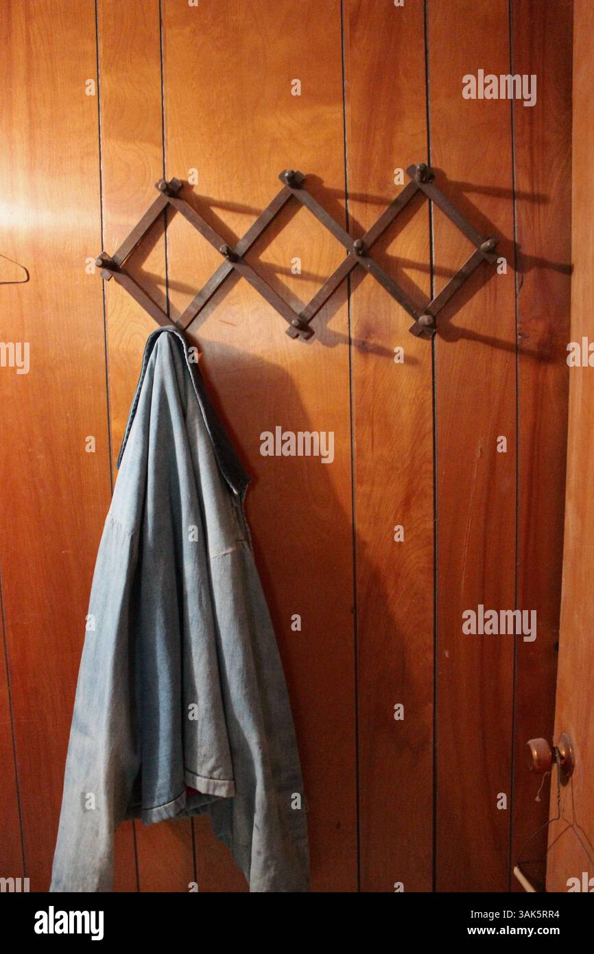 Vintage wooden coat rack with a denim jacket hanging on a warm wooden ...