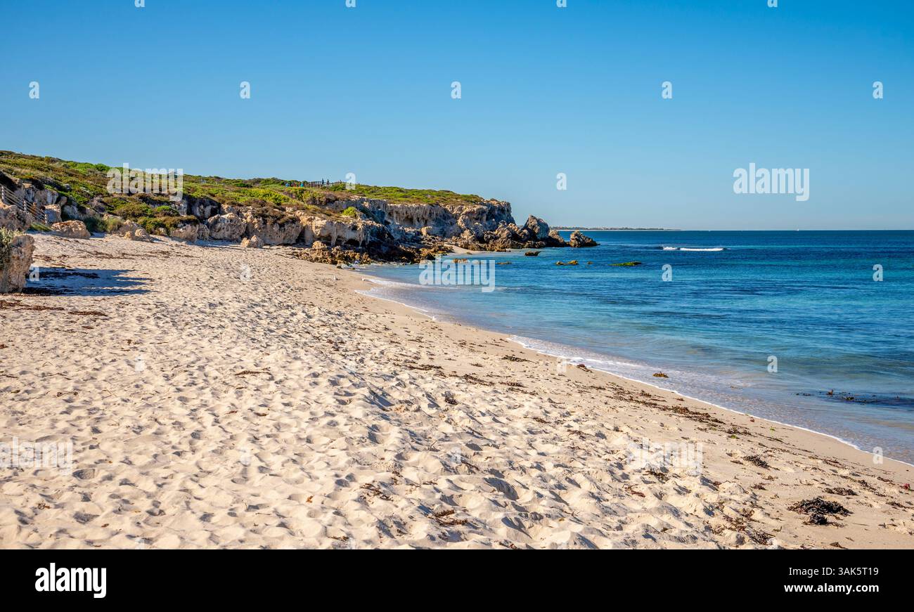 Scenic Coastal Beach with Rolling Waves and Rocky Cliffs Under a Clear ...