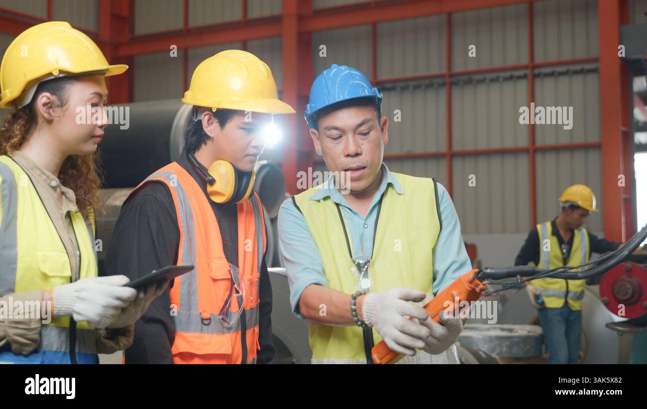 Supervisor senior man training controlling overhead crane with remote ...