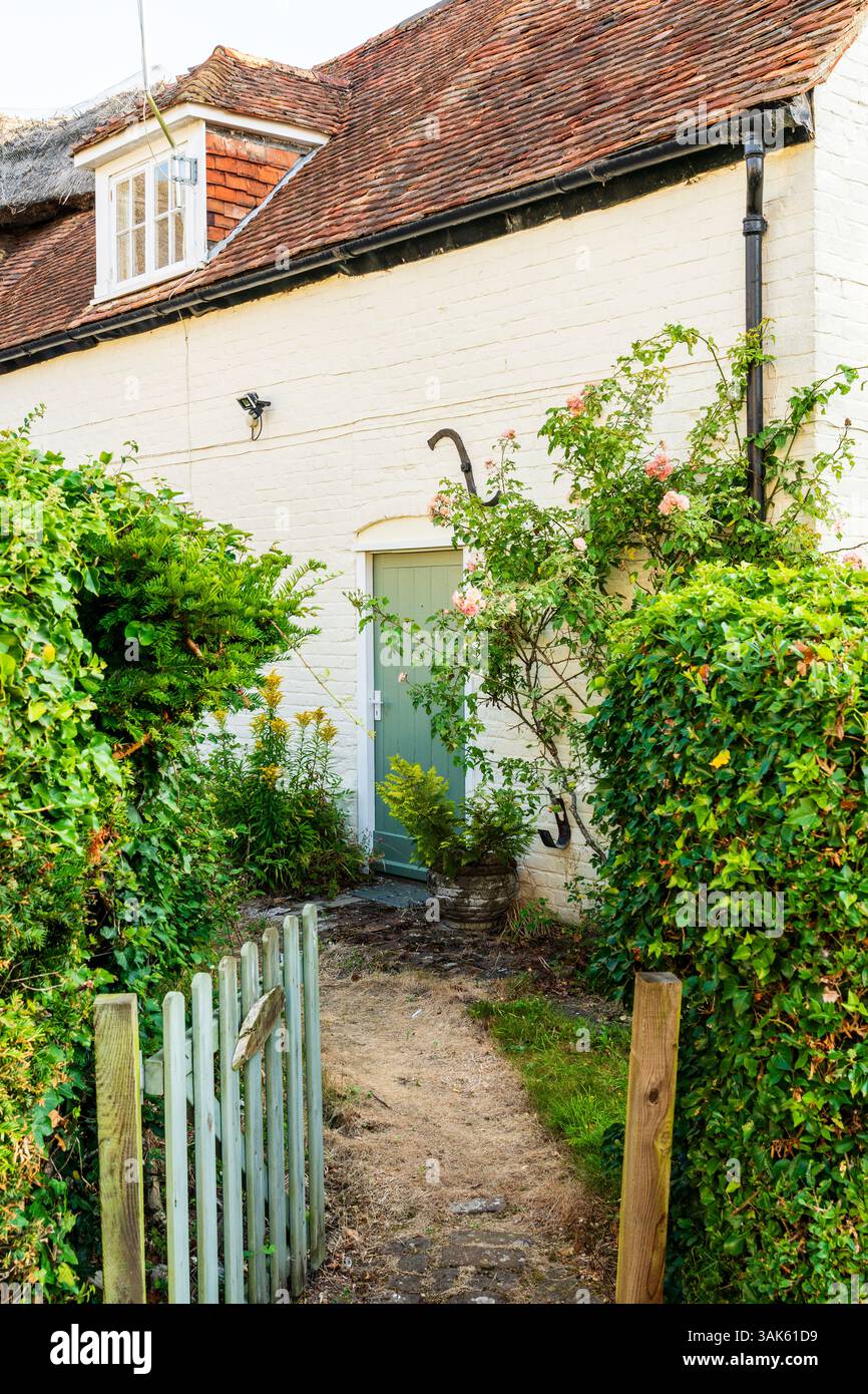 Open green garden gate with pathway leading to a green front door of a ...