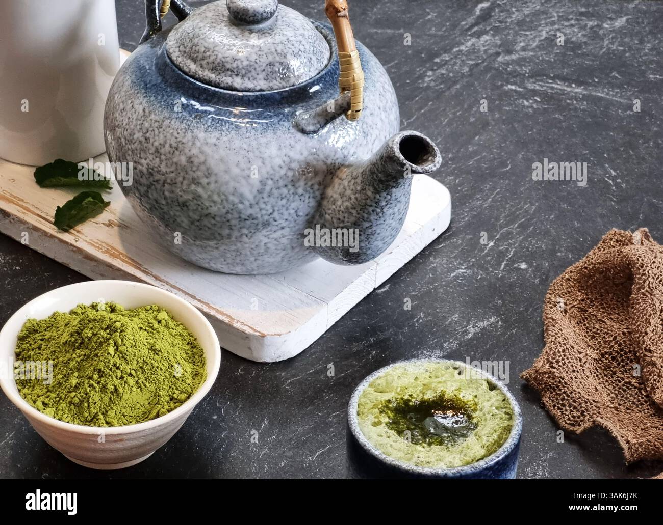 Refreshing matcha latte in a ceramic glass, next to a bowl of bright ...