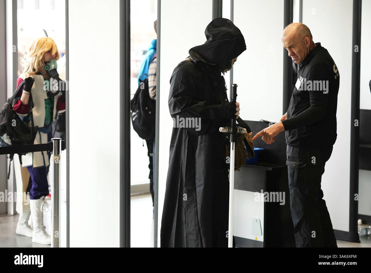 A cosplayer walks through a security during the Comic Con event in ...