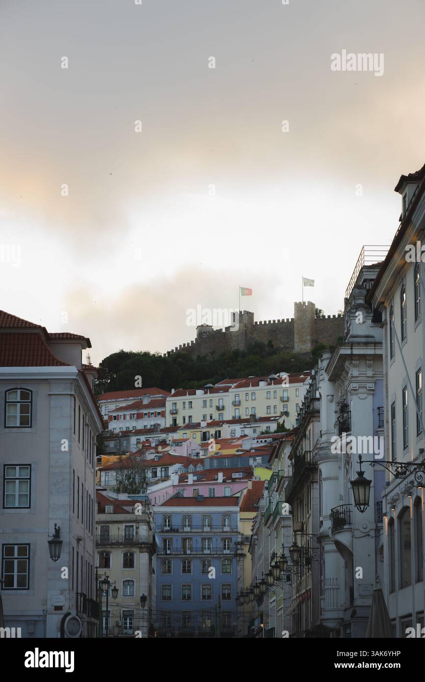 The medieval Castelo de São Jorge looms over a colorful street in ...