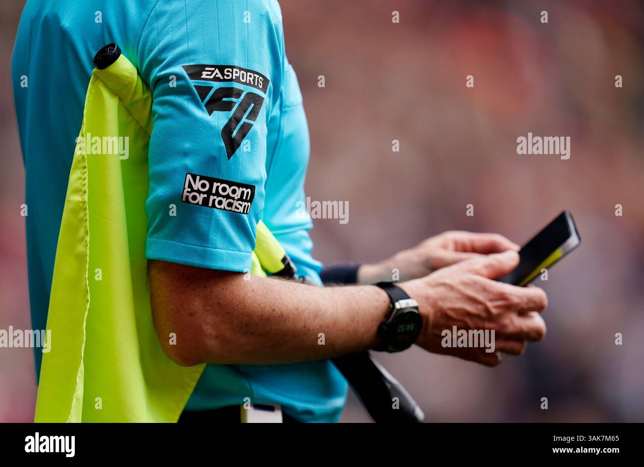 An official wearing a 'No room for racism' badge during the Premier ...