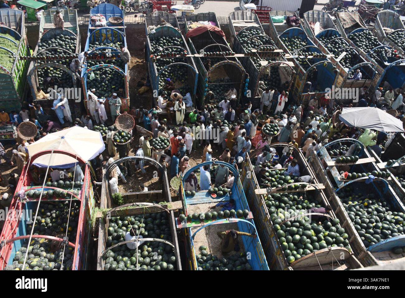 Lahore. 12th Apr, 2025. People trade watermelons at a wholesale market ...