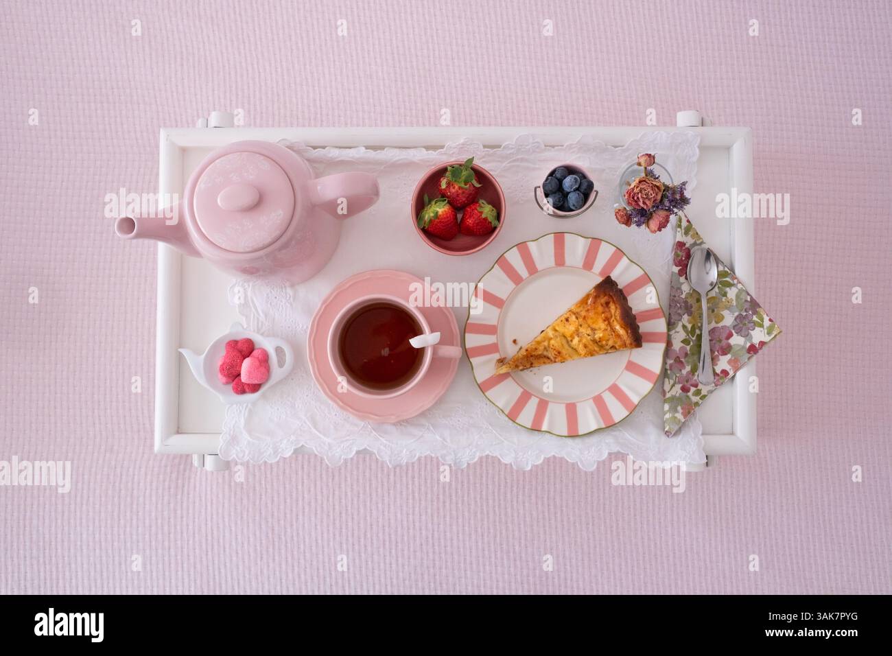 Top view of a beautiful breakfast on a pink bed. Natural light ...