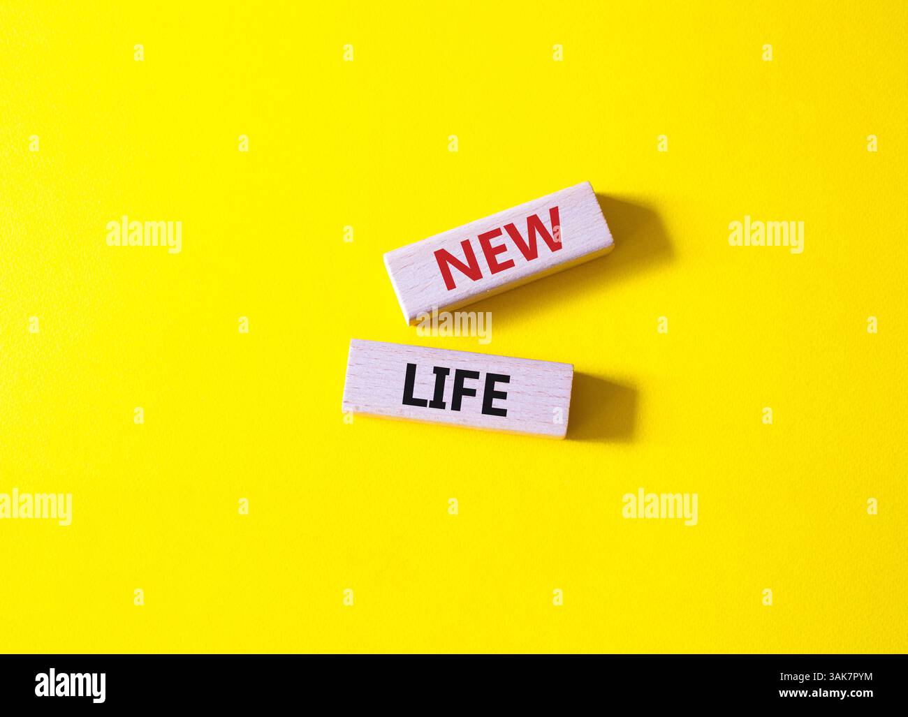 New life symbol. Wooden blocks with words New life. Beautiful yellow ...