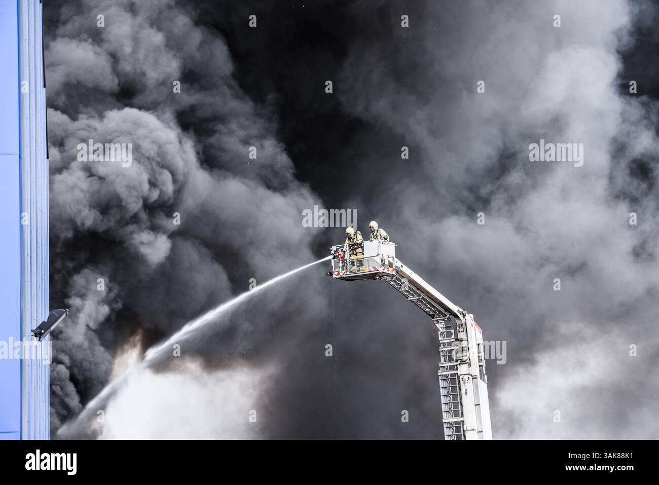 Thick black smoke engulfs an industrial structure in Molndal, Sweden as ...