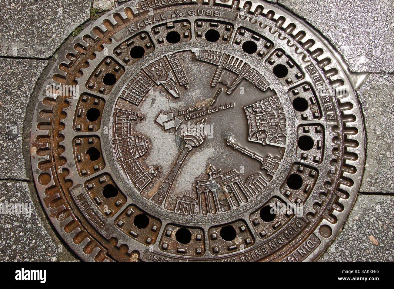 Decorative manhole cover in Berlin, Germany, featuring embossed icons ...