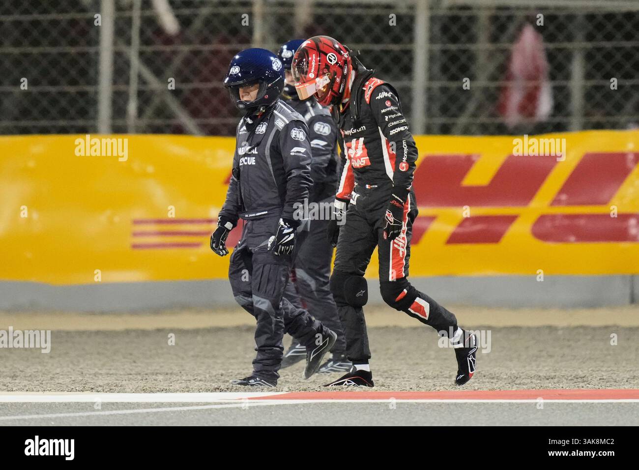Haas driver Esteban Ocon of France walk after a crash during the ...