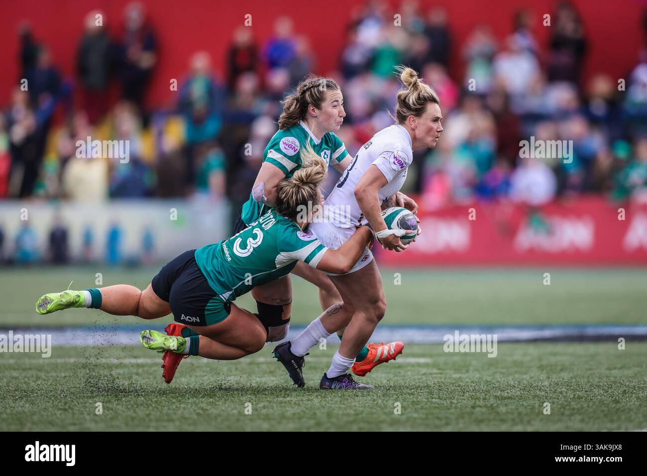 Cork, Ireland. 12 April, 2025. Megan Jones of England is tackled by Aoife Dalton and Eve Higgins ...