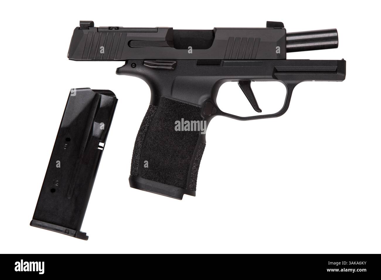 Compact black pistol with exposed barrel and detached magazine ...