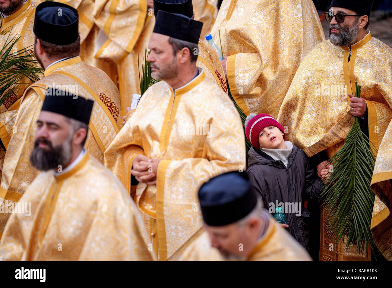 A child stands among priests outside the Patriarchal Cathedral after an ...