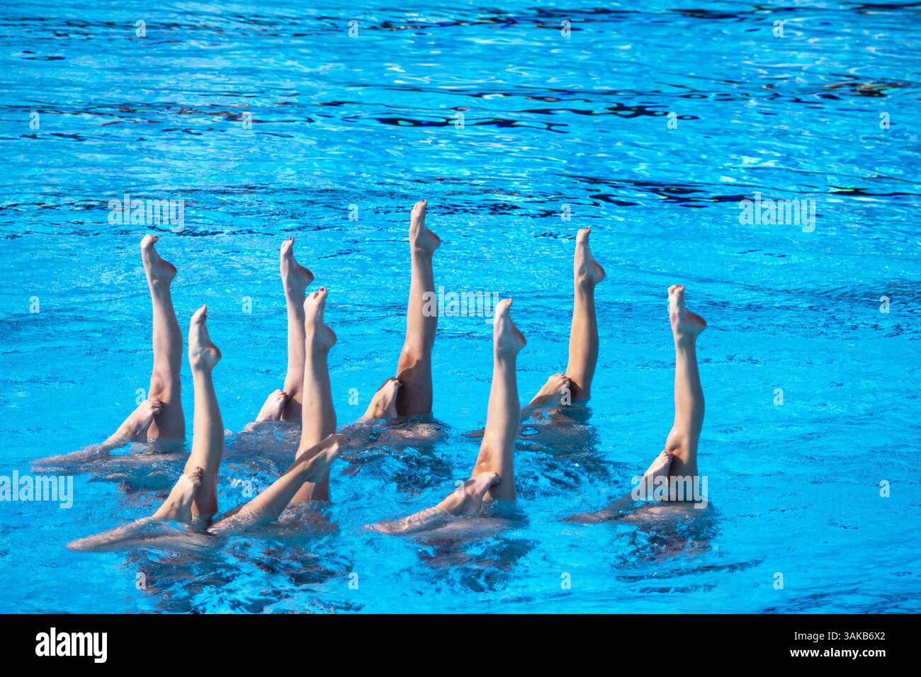 Artistic swimmers team performing synchronized legs choreographed ...
