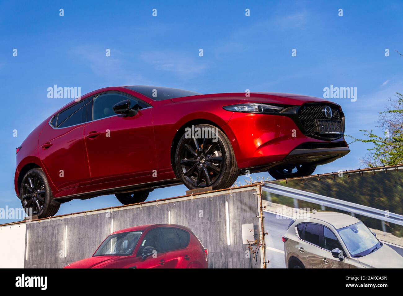 Mazda Motor Corporation logo on car in front of dealership building on ...