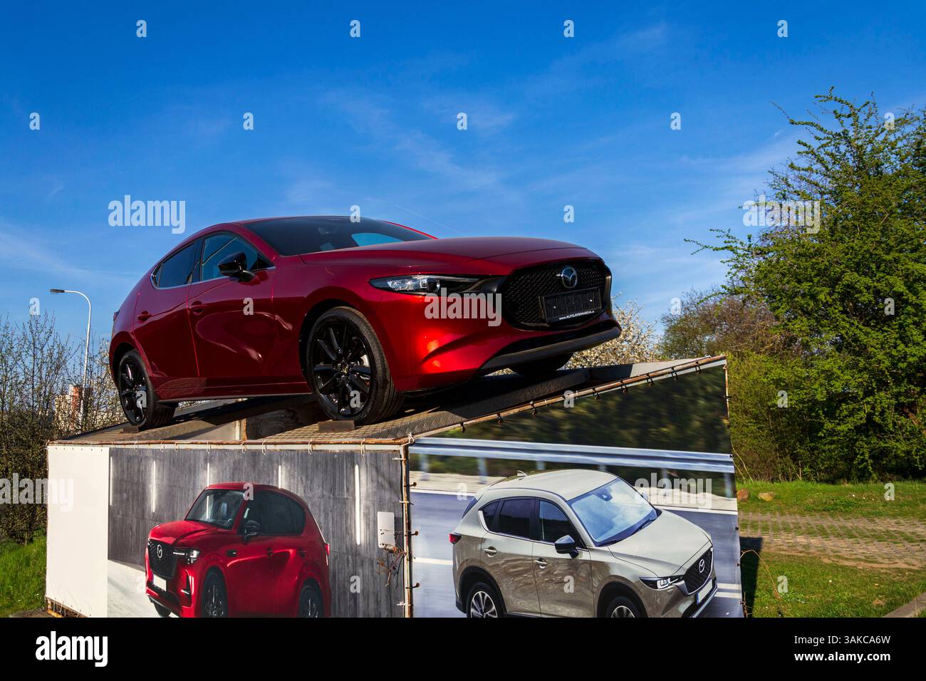 Mazda Motor Corporation logo on car in front of dealership building on ...