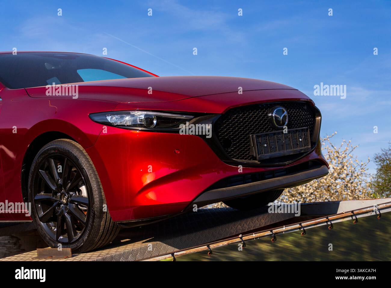 Mazda Motor Corporation logo on car in front of dealership building on ...