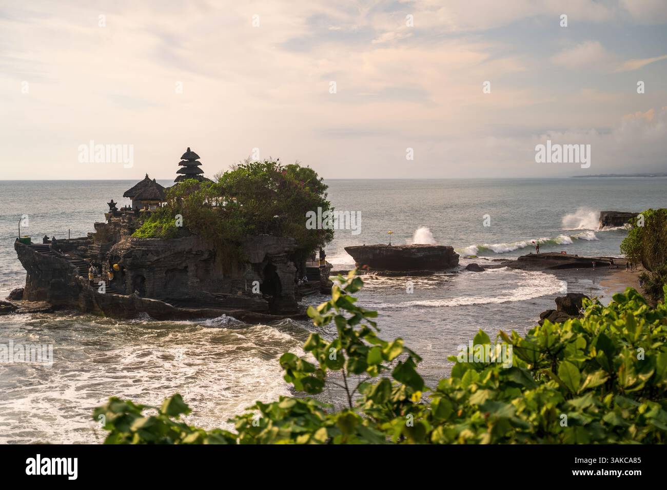Ancient sea temple perched on rocky outcrop in Bali, with crashing ...