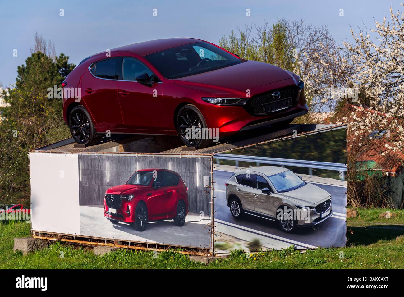 Mazda Motor Corporation logo on car in front of dealership building on ...