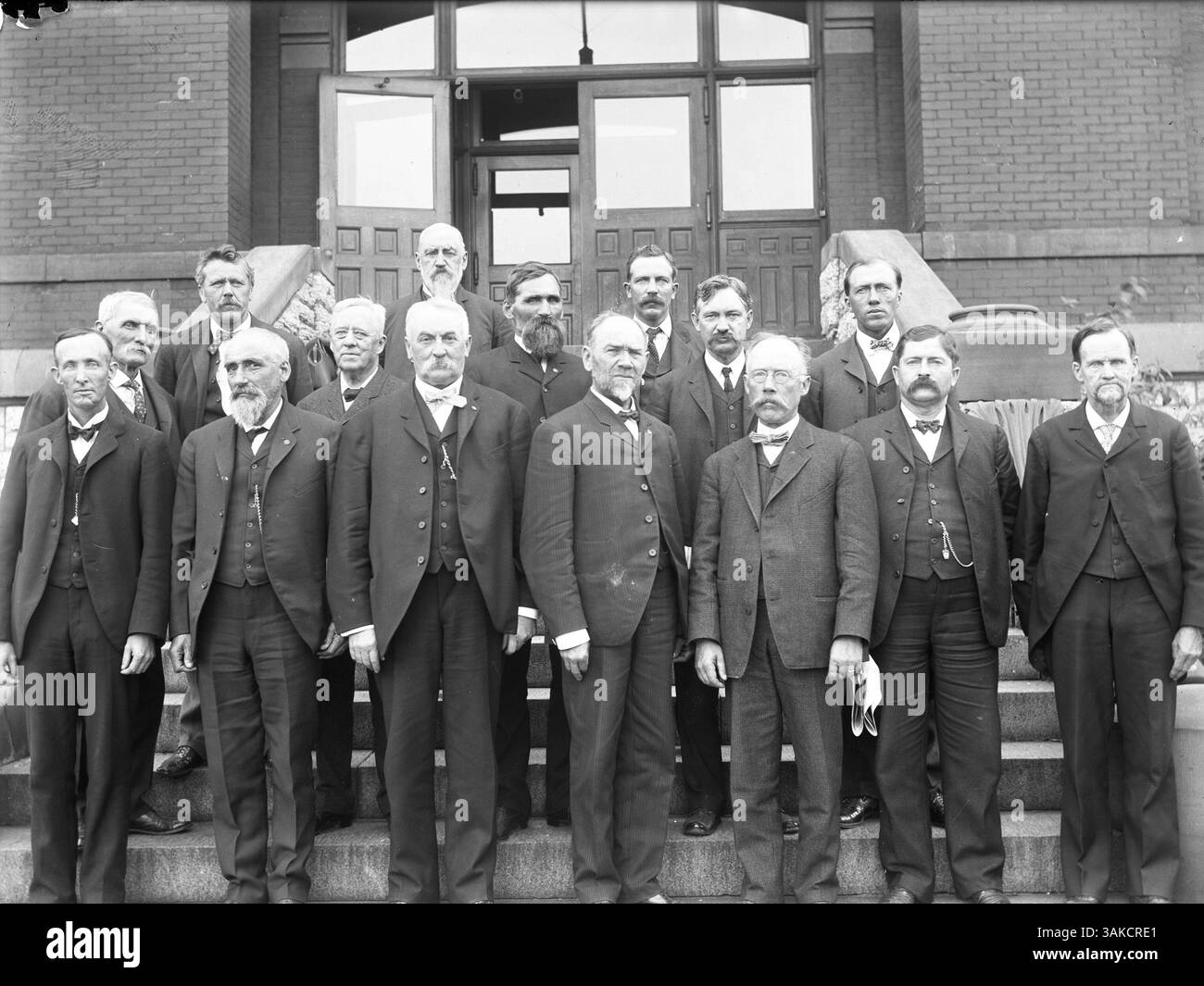 A photograph depicting a group of 15 men standing outside the Minnesota ...