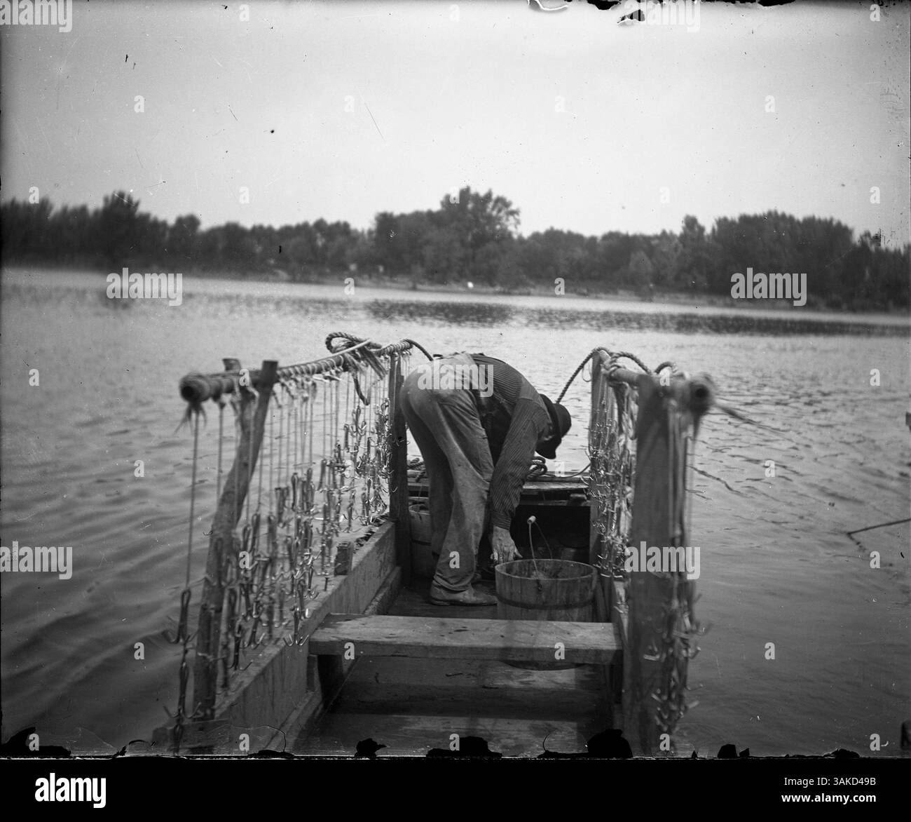 A fisherman stands with his boat and clam hooks on the Mississippi ...