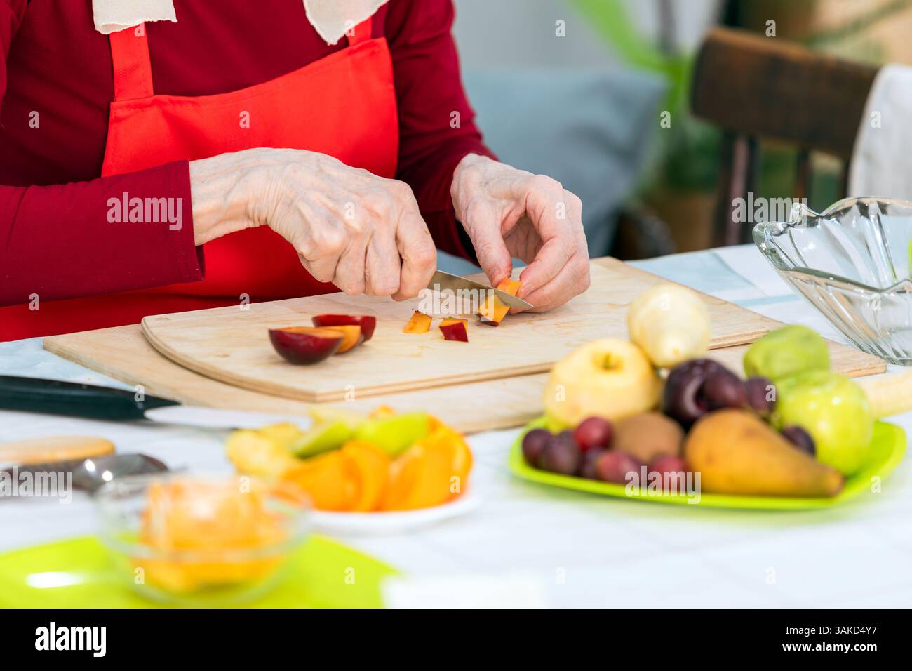Close up of senior woman cutting fruits in the kitchen at home Stock ...