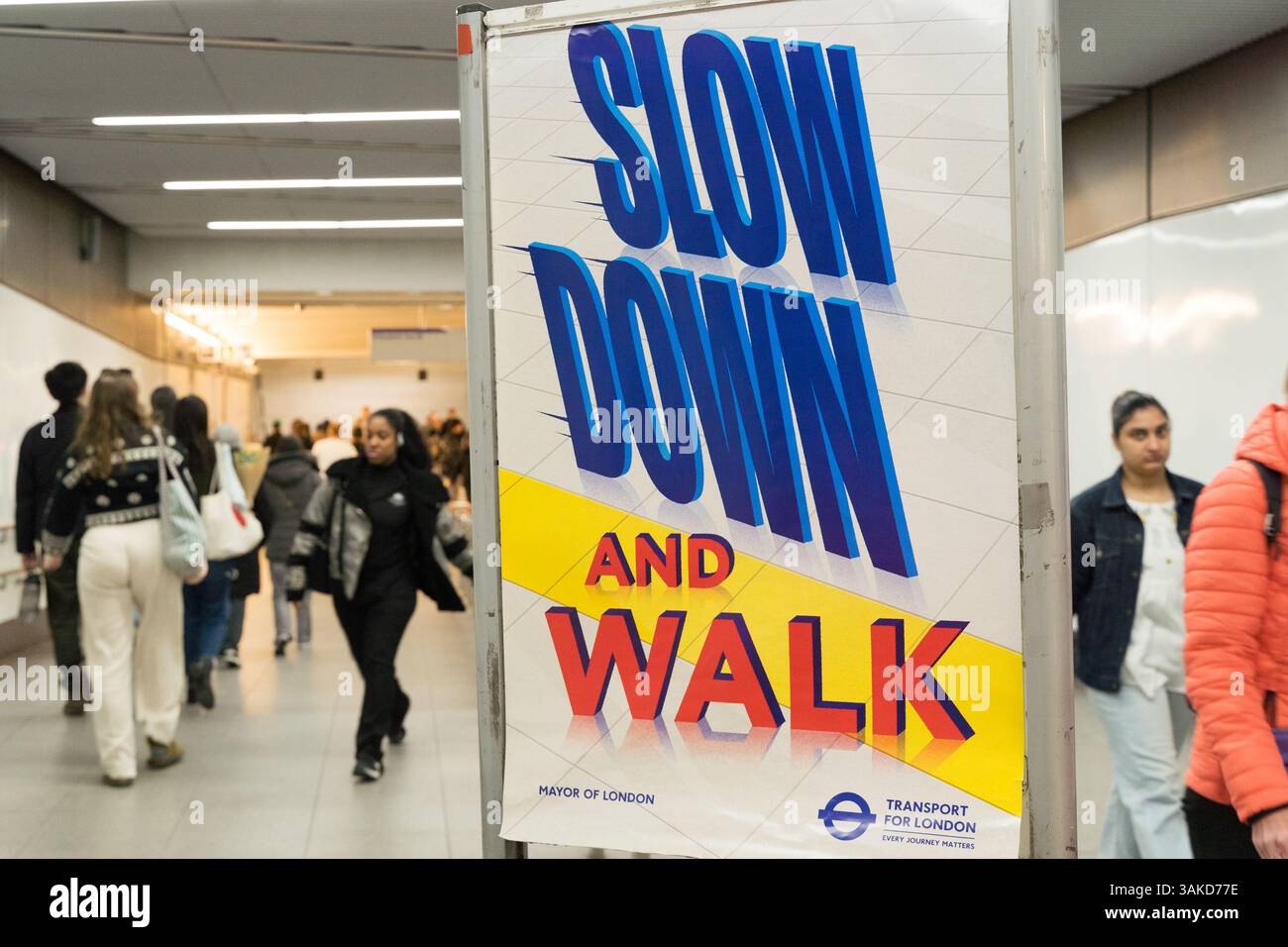SLOW DOWN AND WALK poster on the walkway of London Underground station ...