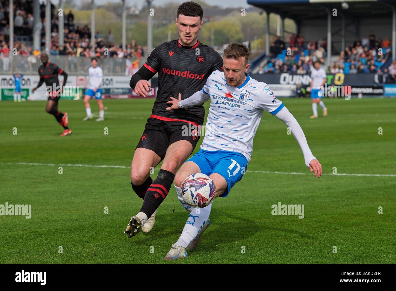 Barrow's Elliot Newby in action with Connor Barrett of Walsal during ...