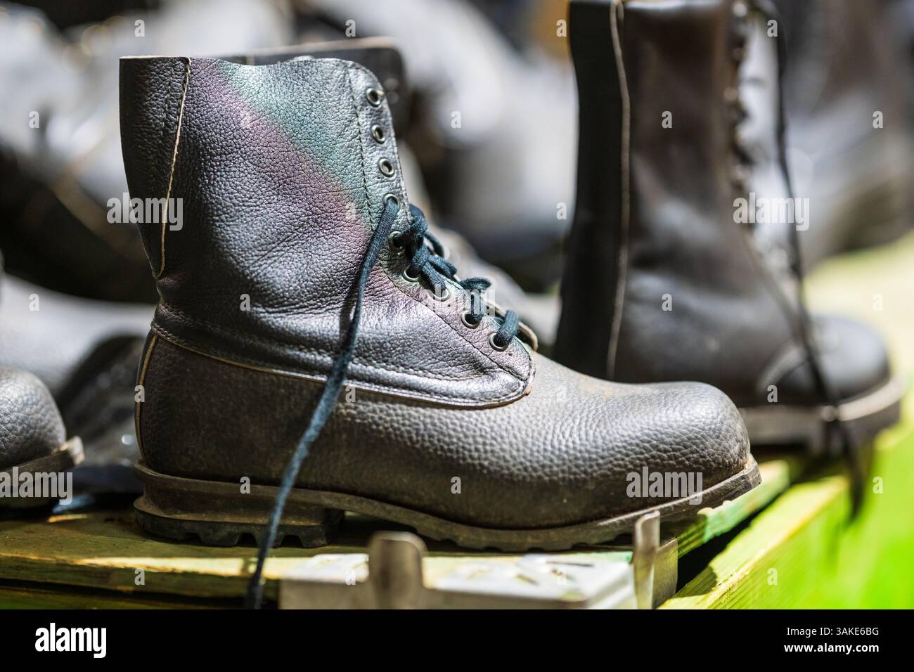 Surplus military boots in a warehouse Stock Photo - Alamy