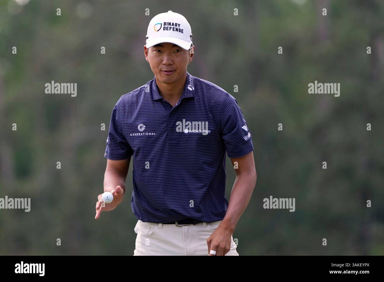 Michael Kim waves after making a putt on the 14th hole during the third round at the Masters ...