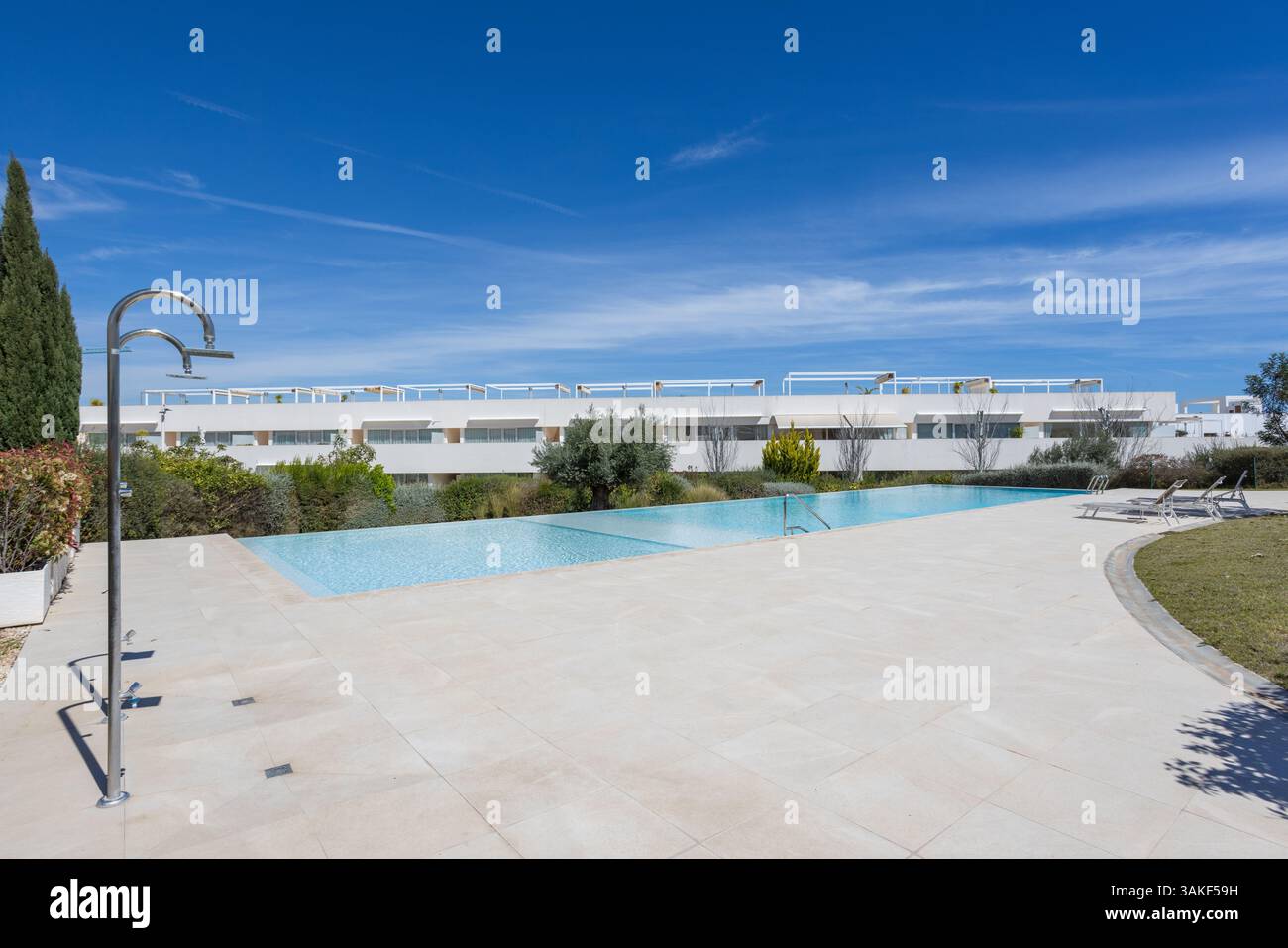 Wide infinity pool with stainless steel outdoor showers and tiled ...