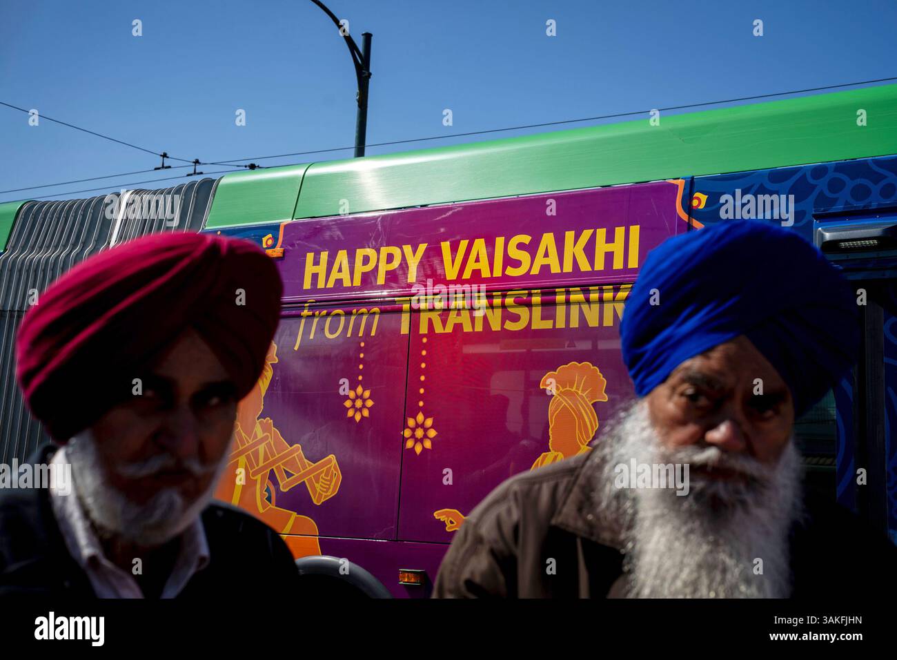 People walk past a bus during the Vaisakhi parade in Vancouver, B.C ...