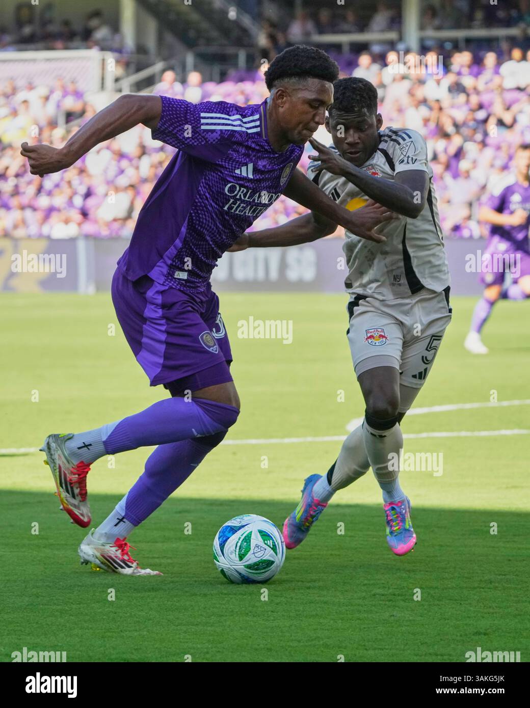 Orlando City defender Alex Freeman, left, makes a move to get past New ...