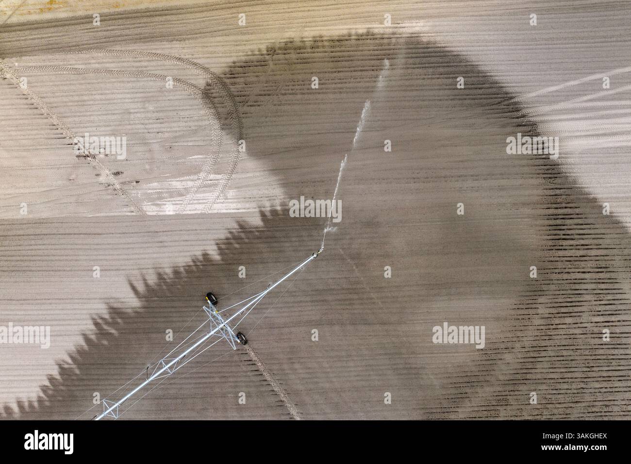 Agricultural irrigation sprinkler watering dry soil on farm field for ...