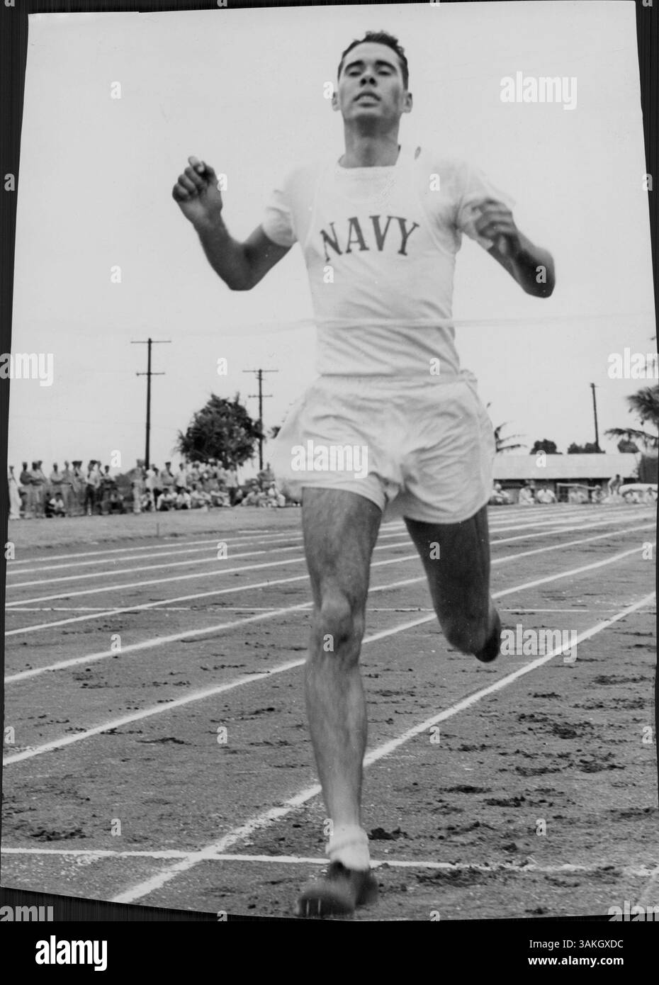 Floyd Foslien is captured crossing the finish line at a track and field ...