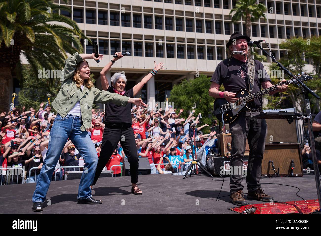 Neil Young, right, performs with Maggie Rogers, left, and Joan Baez ...