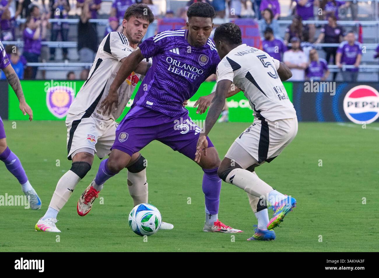 Orlando City defender Alex Freeman, center, tries to move the ball ...