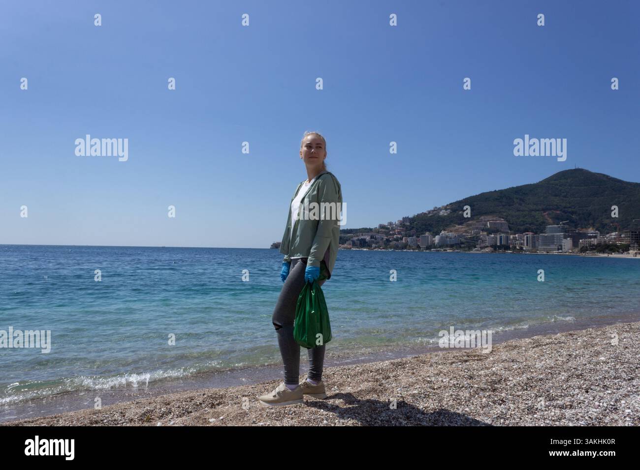 Woman volunteer helps clean the beach of garbage. Earth day and ...