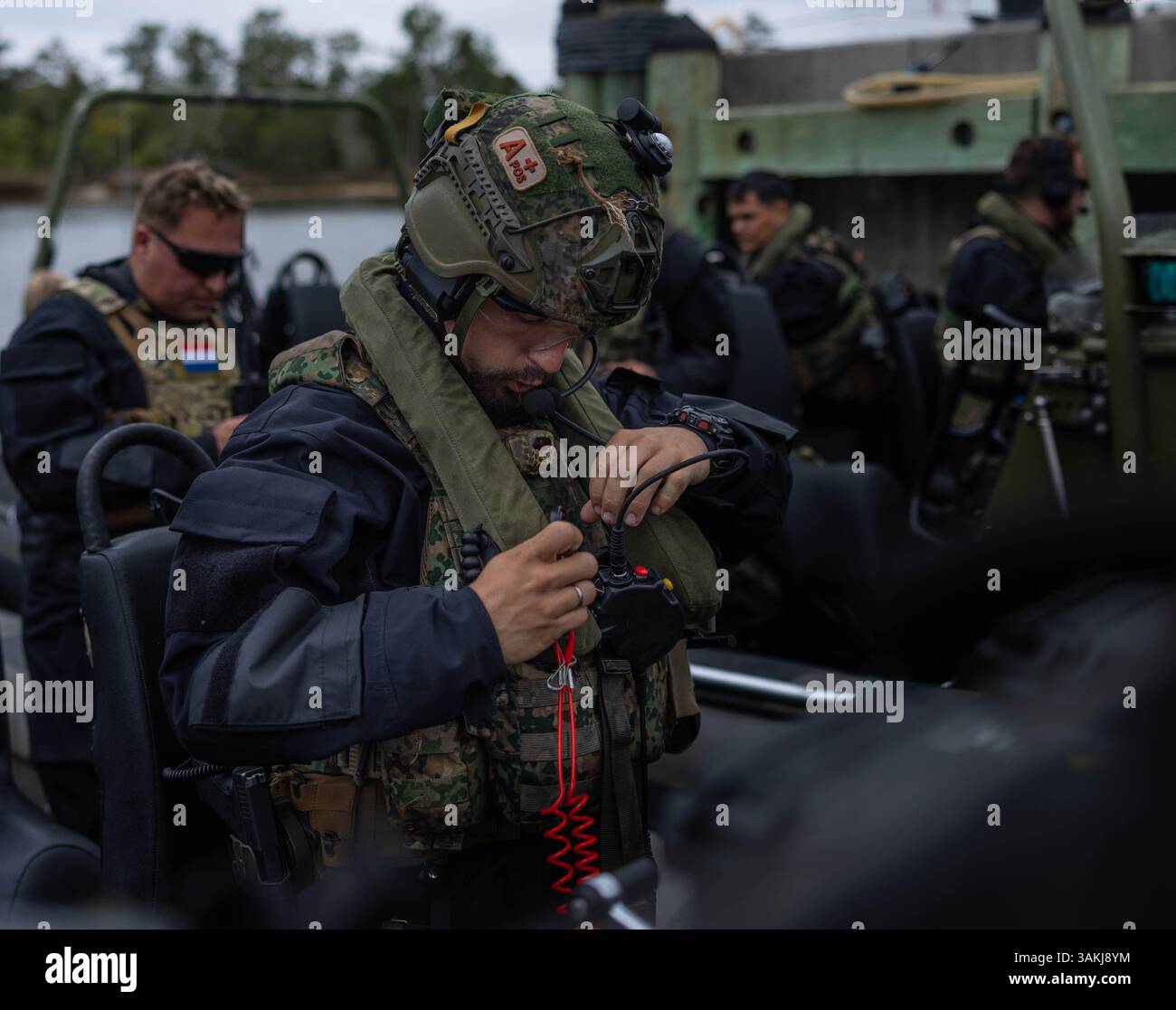 A Korps Marinier with the Royal Netherlands Marine Corps attaches a ...