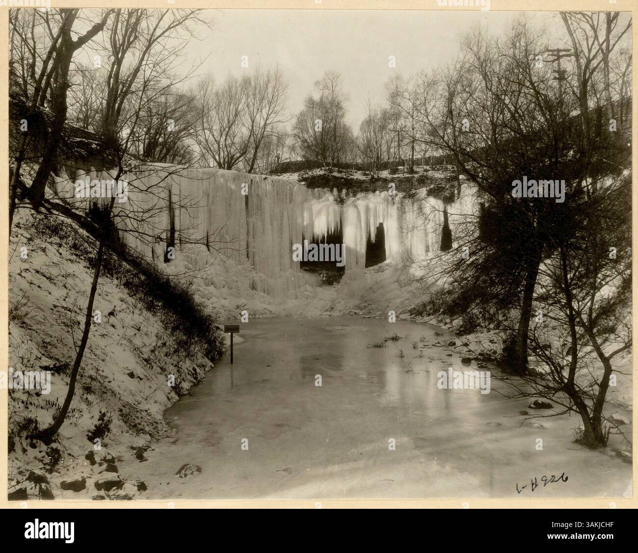 This image depicts Minnehaha Falls during winter, capturing the frozen ...