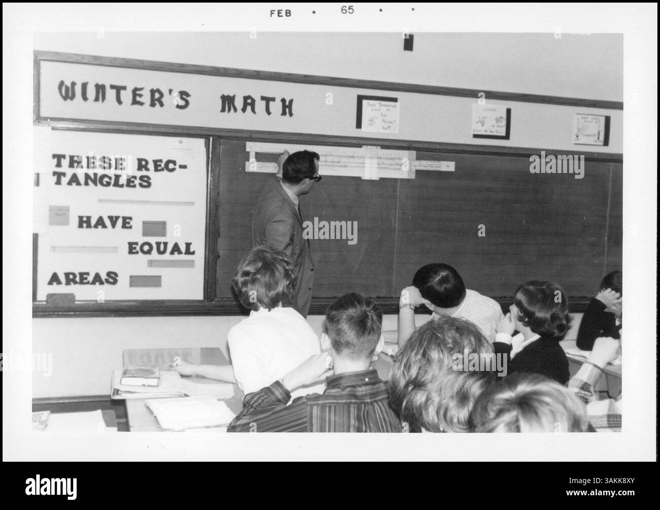 This image from February 1965 shows a classroom with a slide rule, a ...
