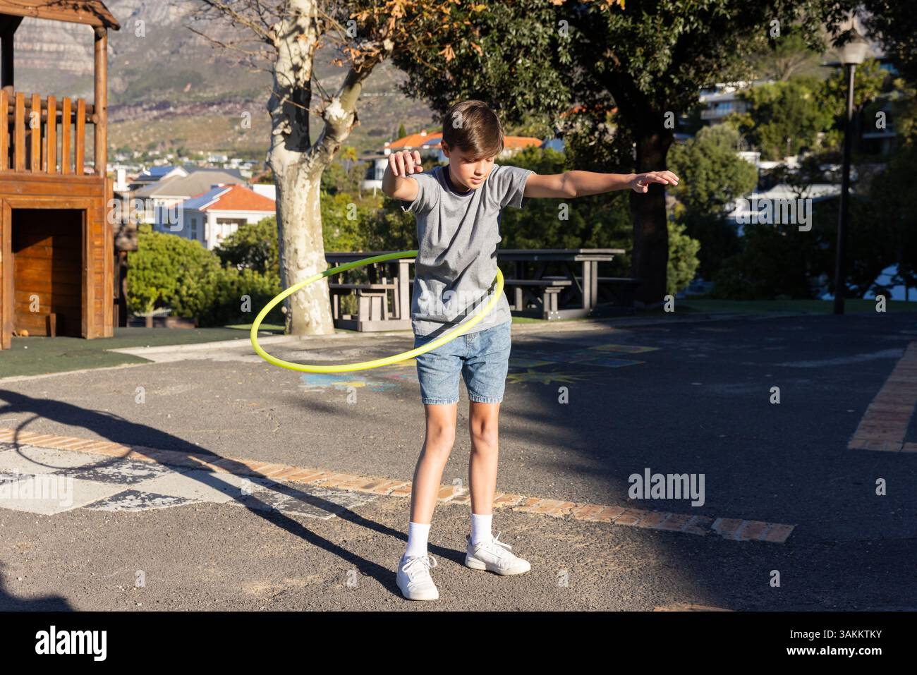 Playing with hula hoop, boy enjoying outdoor activity at school ...