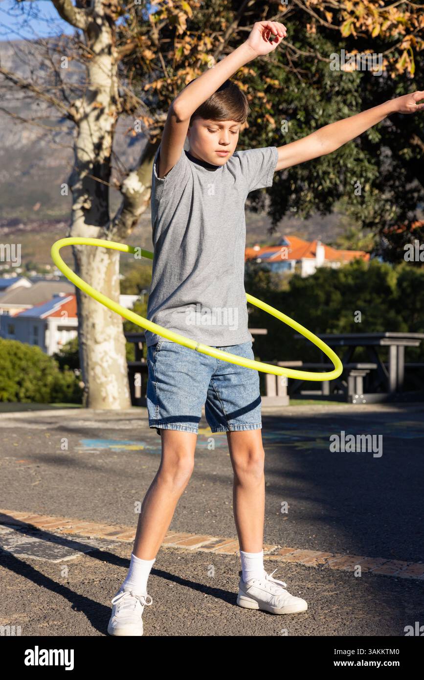 Playing with hula hoop, boy enjoying outdoor activity after school ...