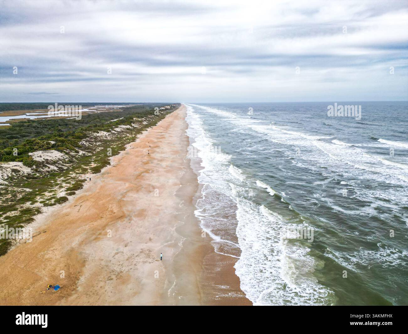 Wide Sandy Beach with Gentle Slope into Clear Blue-Green Ocean Under a ...