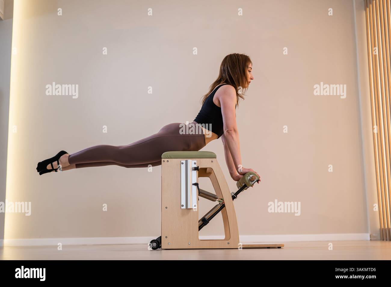 Asian woman doing pilates classic chair Stock Photo - Alamy