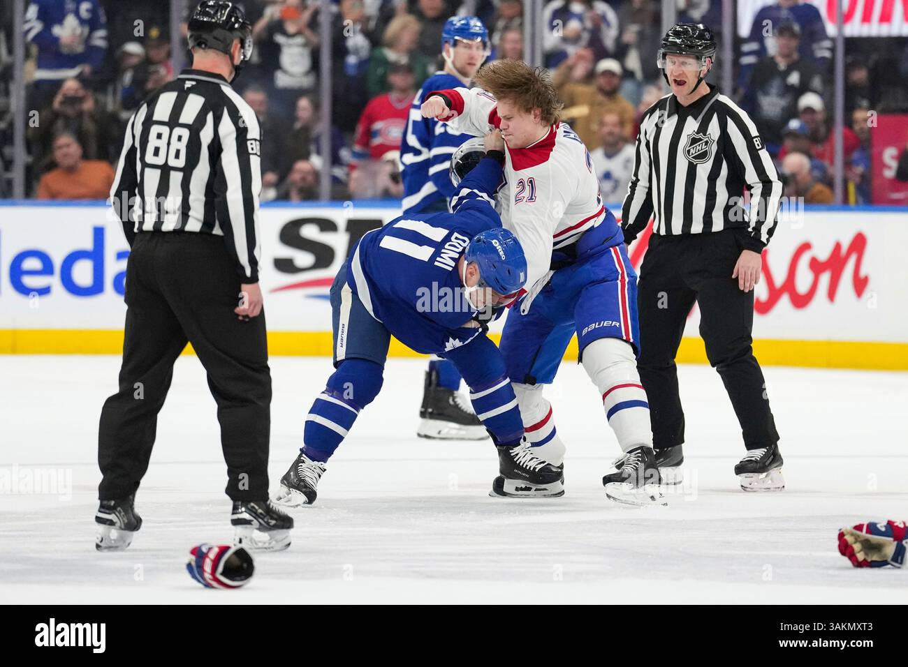 Montreal Canadiens' Kaiden Guhle (21) and Toronto Maple Leafs' Max Domi (11) fight during the ...