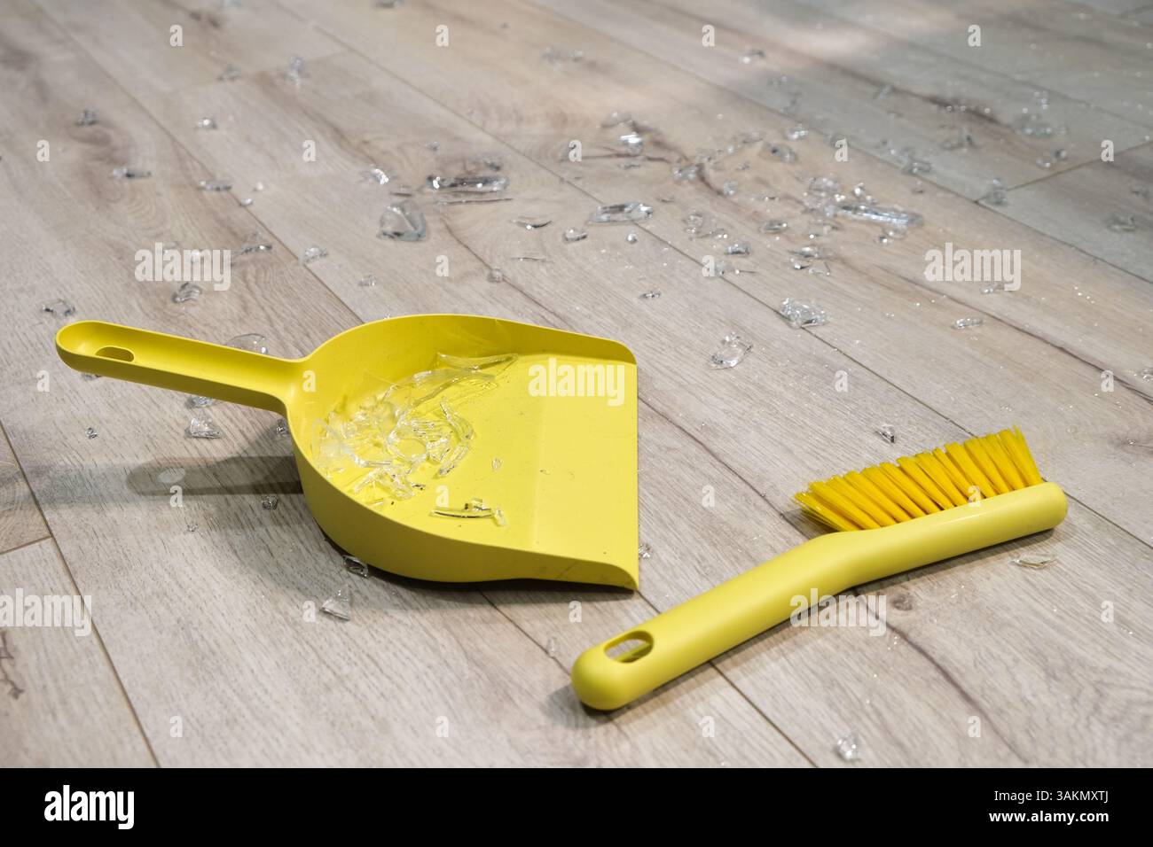 Sweeping broken glass with yellow cleaning tools broom and dustpan on ...