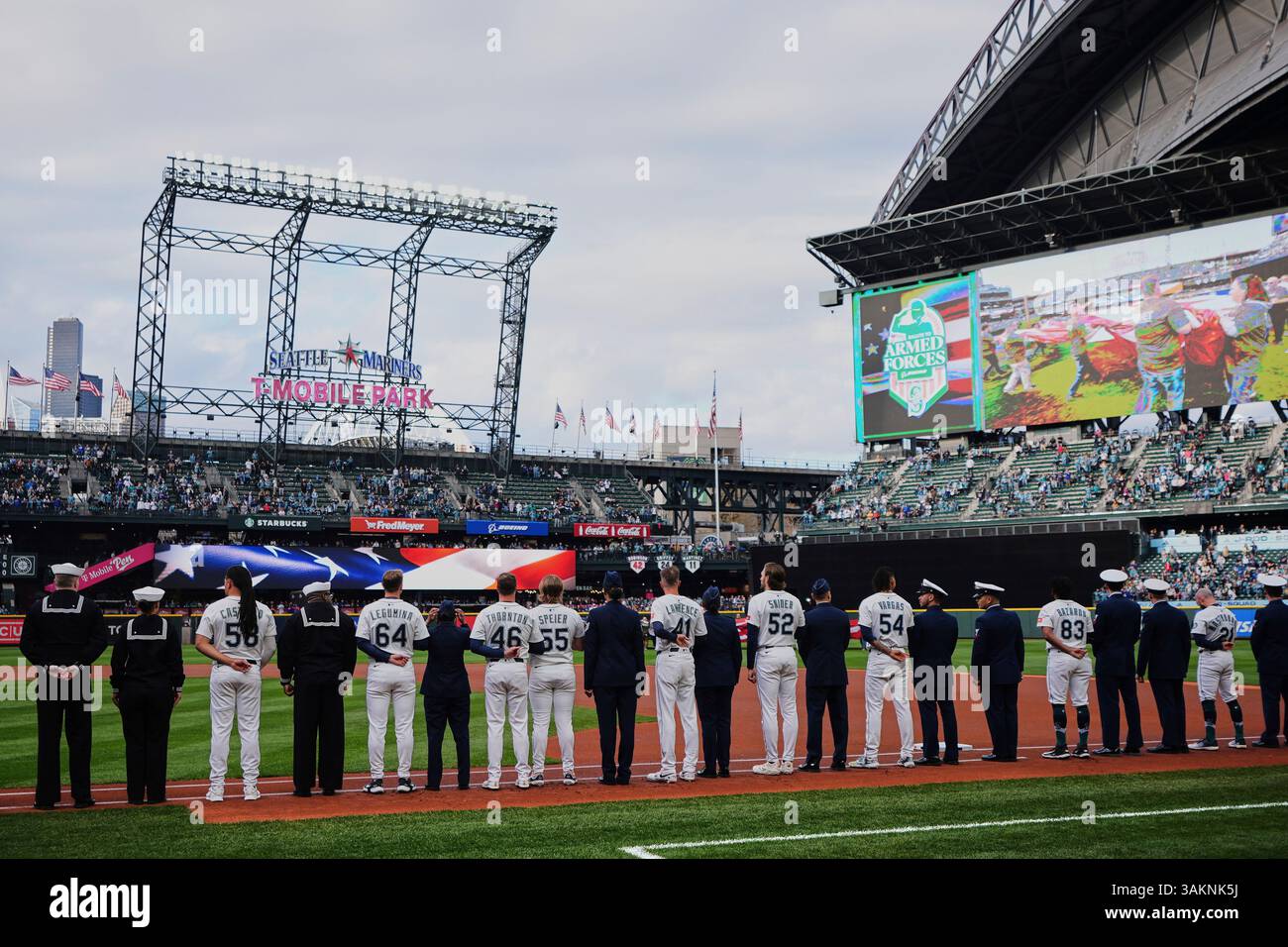 The Seattle Mariners stand with members of the armed forces during a ...